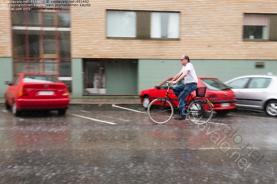 Kuva: Pyöräilijä sateessa - rankkasade vesisade kova vesi kesä pisara ...